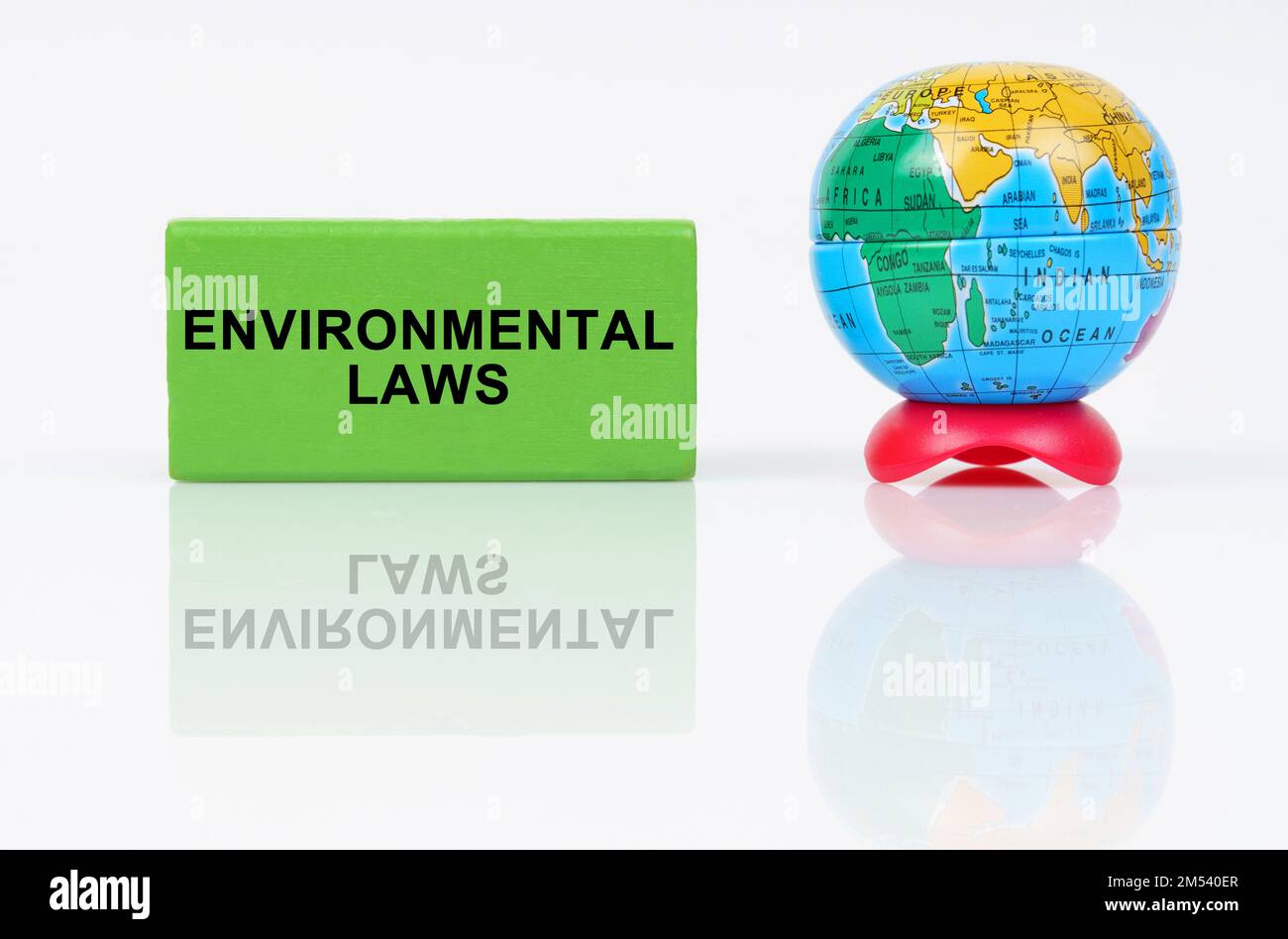 Ecological concept. On a reflective surface is a globe and a green sign ...