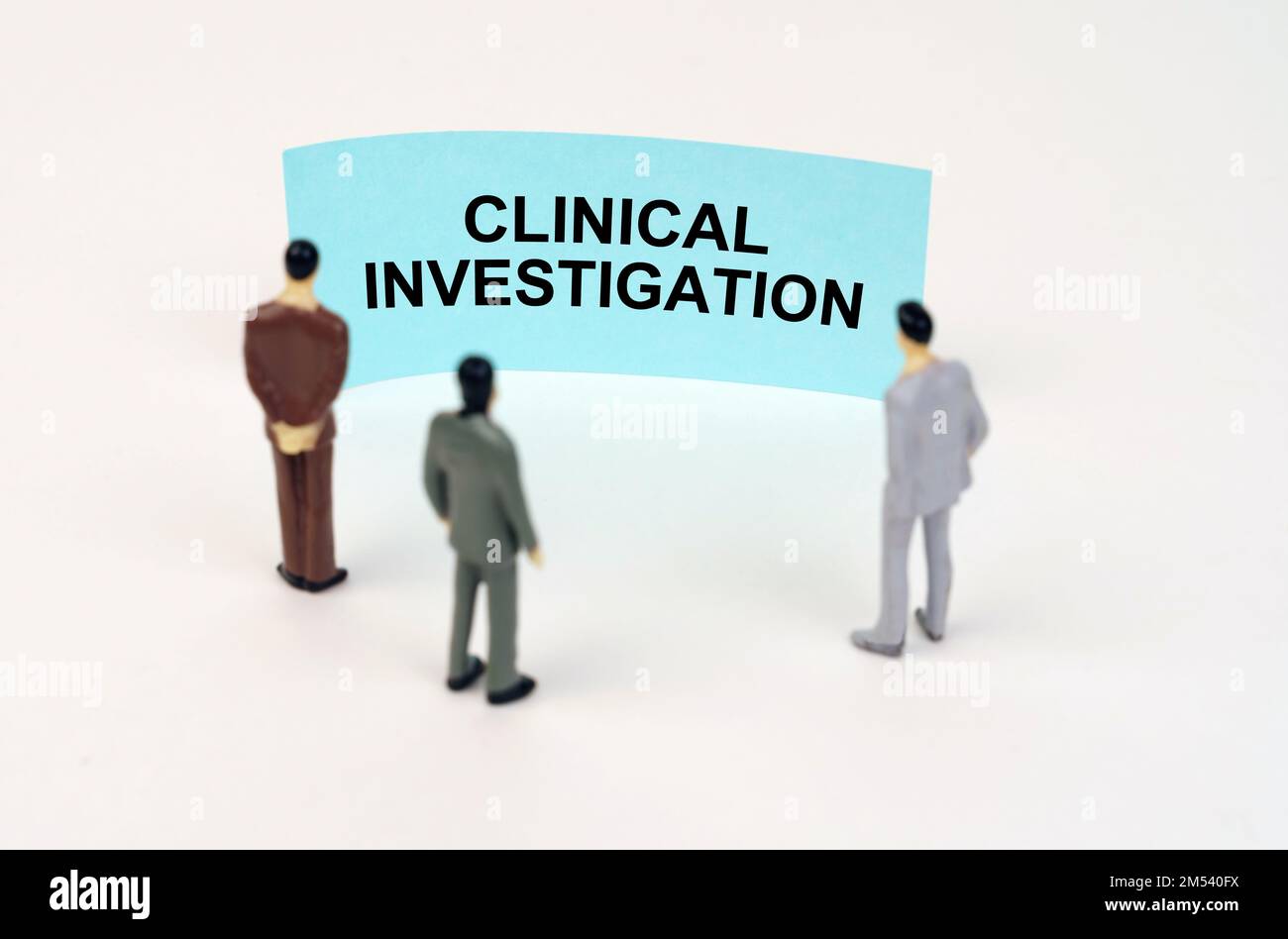 Medical concept. Miniature figures of people stand in front of a blue ...