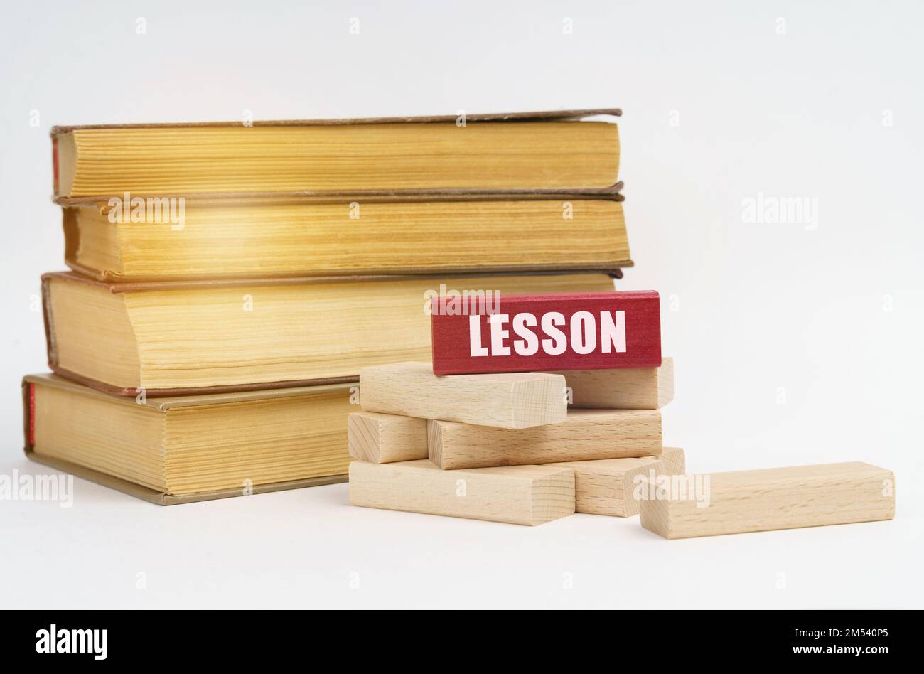 Education concept. On a white surface, a stack of books and wooden ...