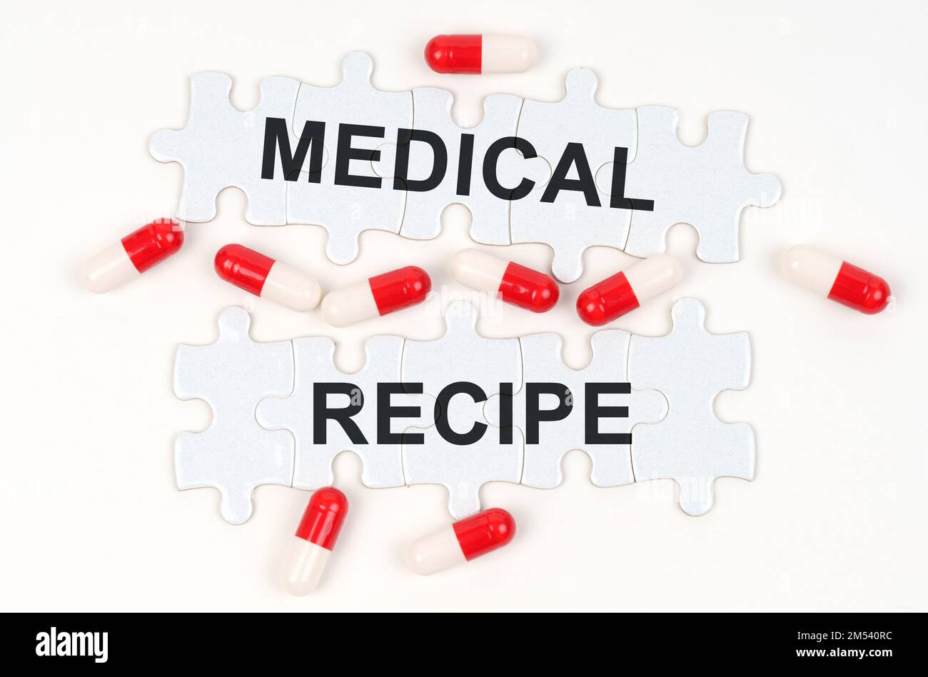 Medical concept. On a white surface, tablets and puzzles with the ...