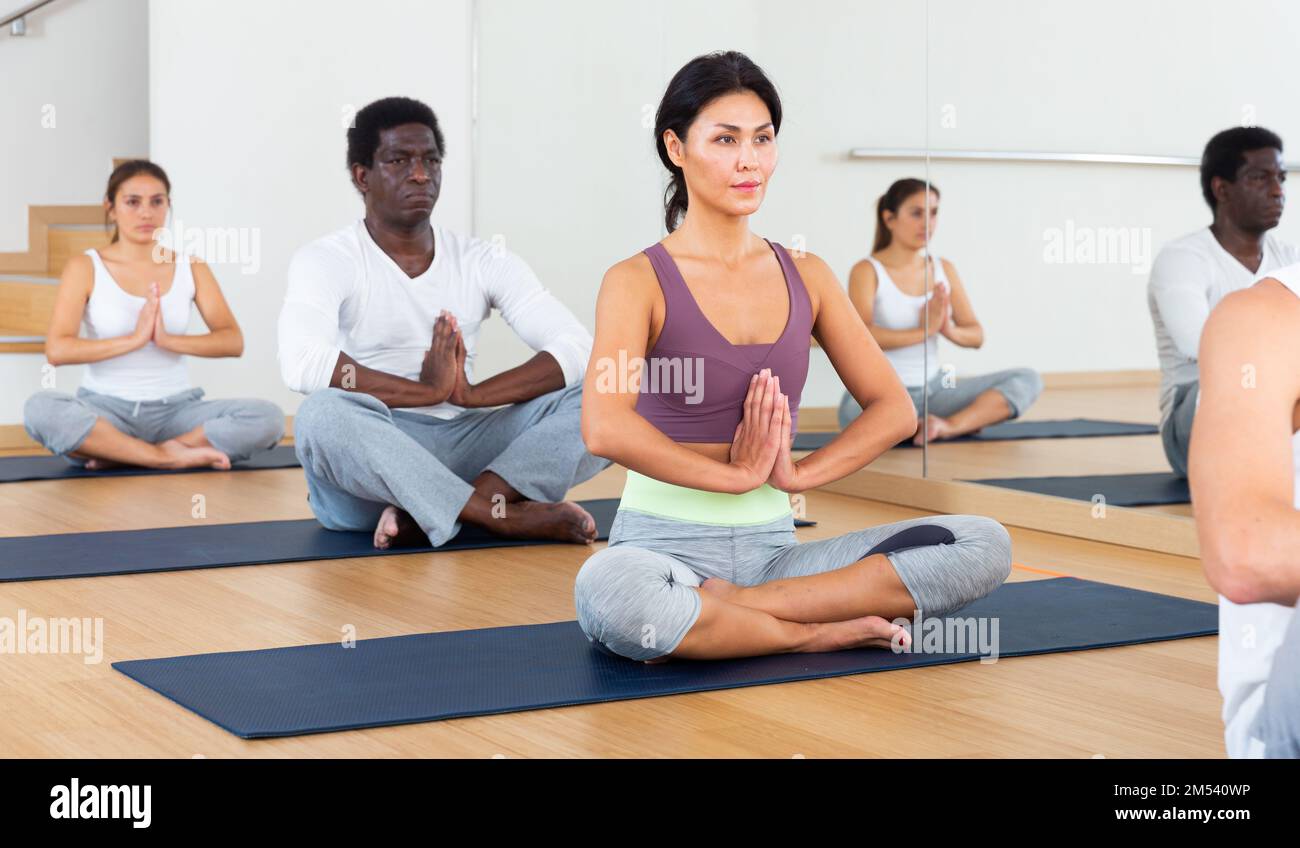 Group of people practicing yoga in dance hall Stock Photo - Alamy