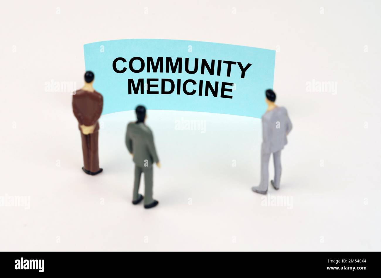 Medical concept. Miniature figures of people stand in front of a blue ...