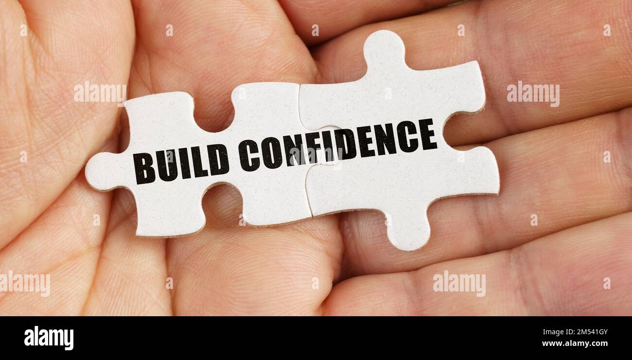 Business concept. In the hand of a man are puzzles with the inscription ...