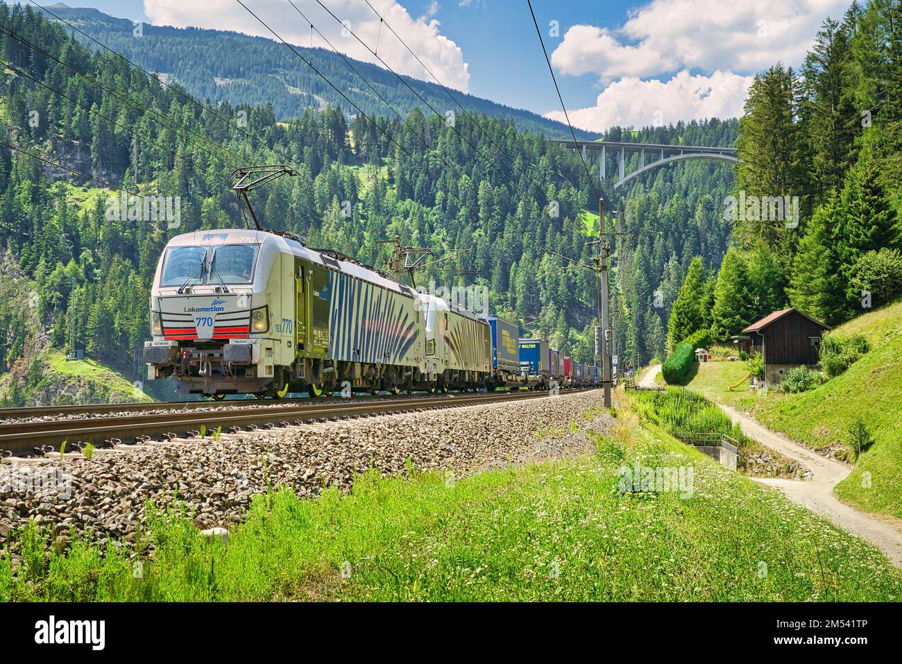 A beautiful view of a modern locomotive with a freight train during ...