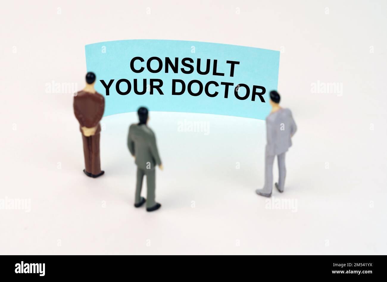 Medical concept. Miniature figures of people stand in front of a blue ...