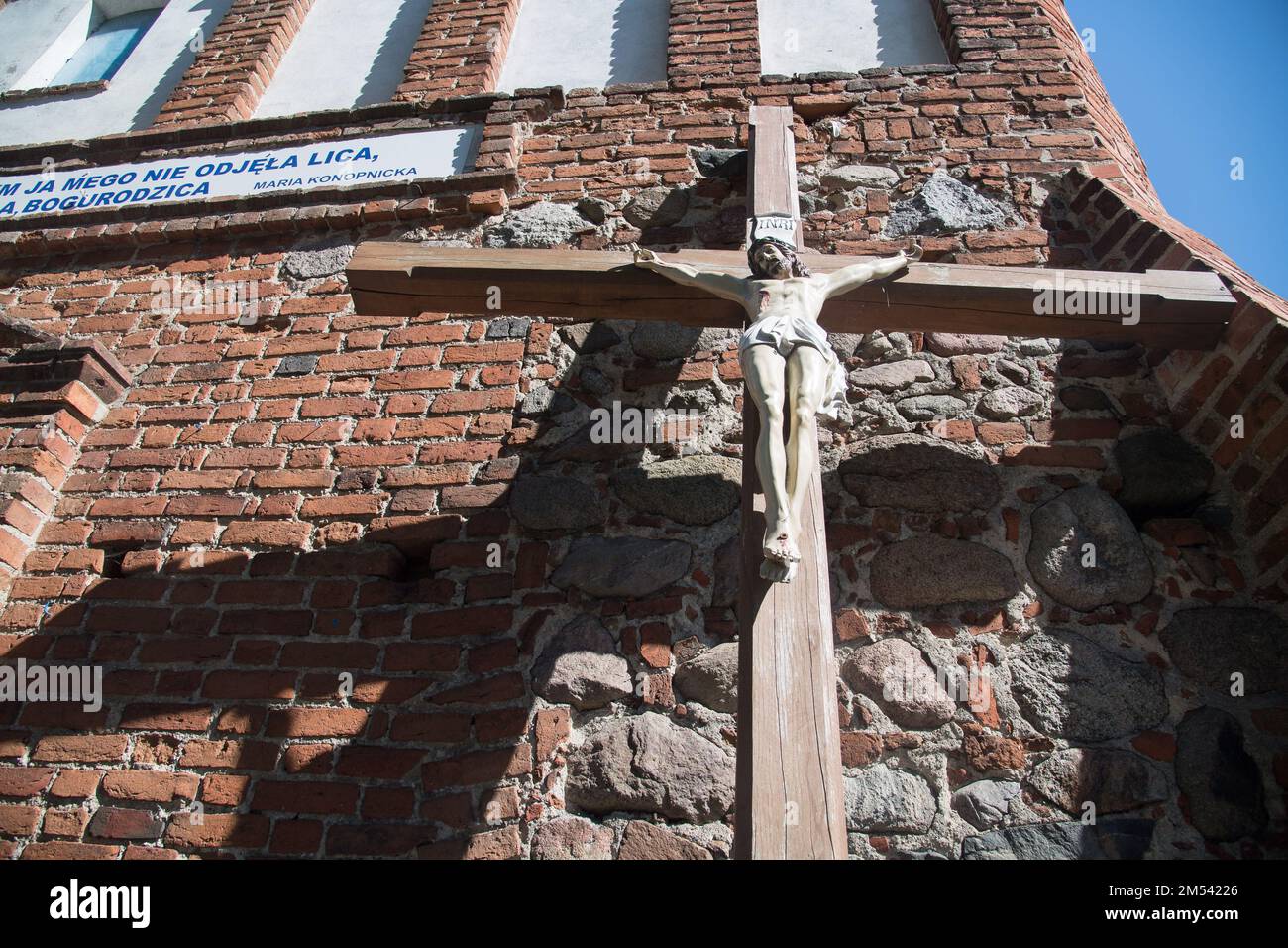 Cross in front of gothic The Feast of the Cross church in Lisewo ...