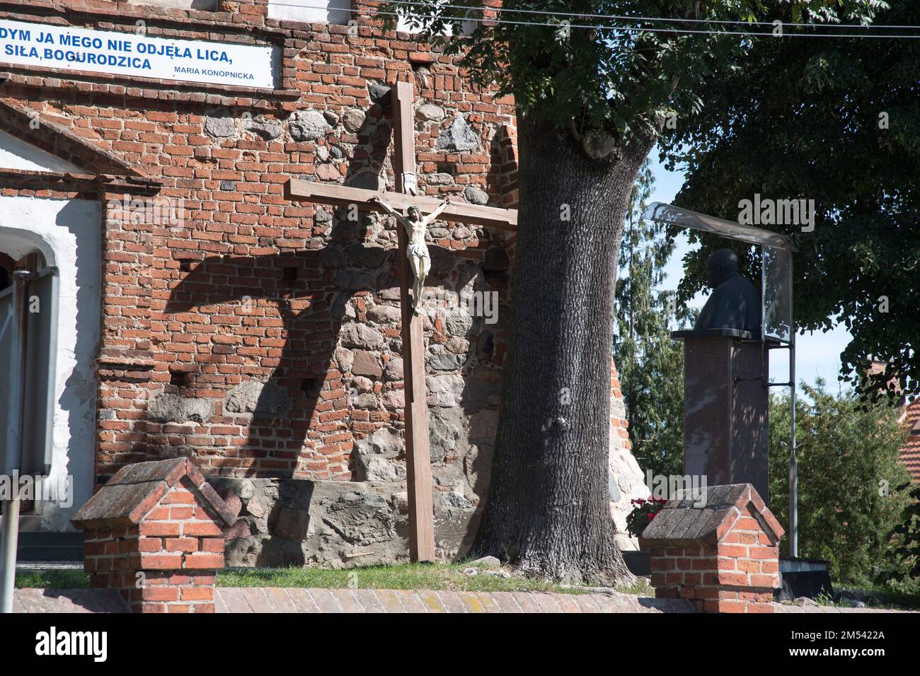 Cross in front of gothic The Feast of the Cross church in Lisewo ...