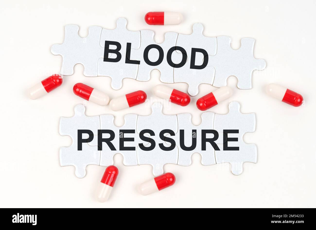 Medical concept. On a white surface, tablets and puzzles with the ...