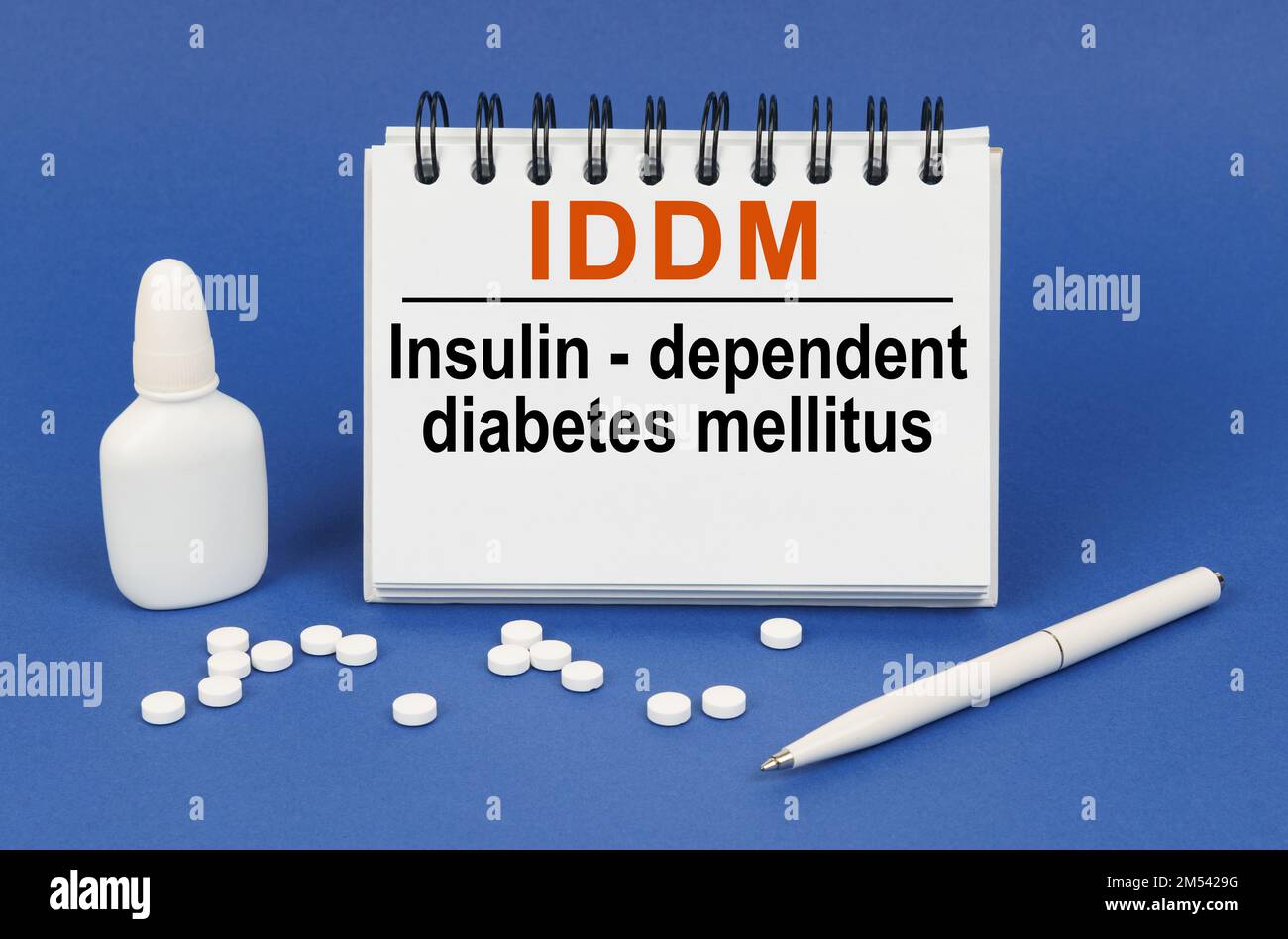 Medical concept. On a blue background, a pen, tablets and a notepad ...