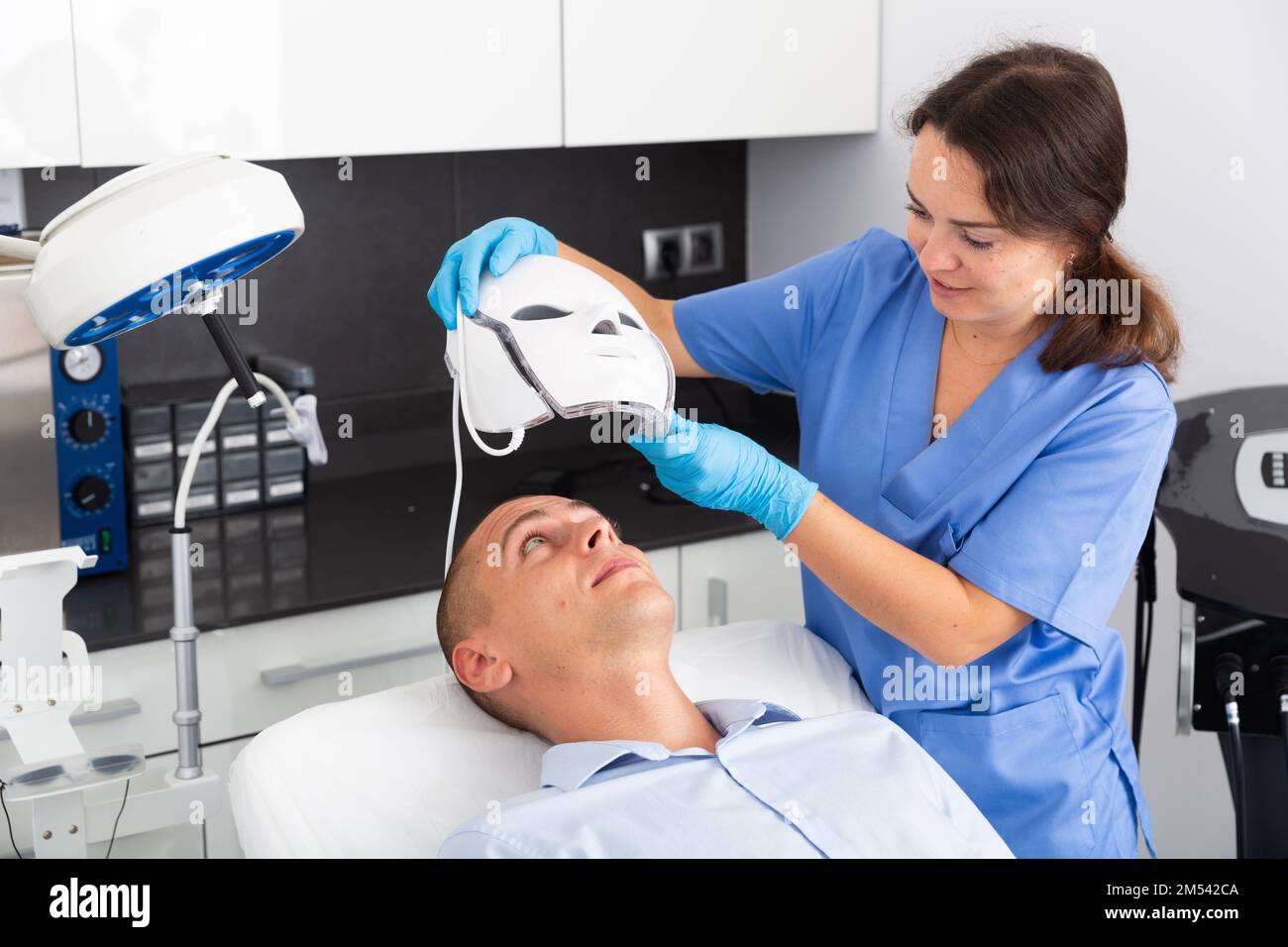 Man getting LED facial mask light therapy Stock Photo - Alamy
