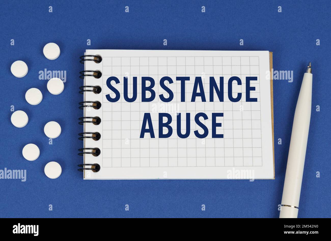 Medical concept. On a blue background, a pen, tablets and a notepad ...