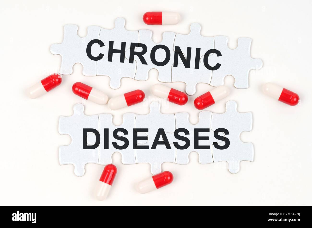 Medical concept. On a white surface, tablets and puzzles with the ...