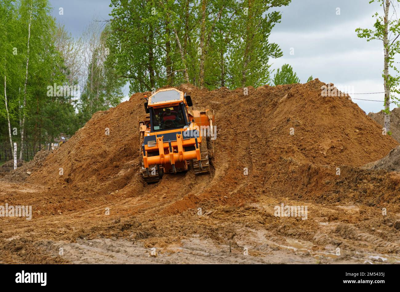 Building concept. The bulldozer collects earth from the pit into the ...