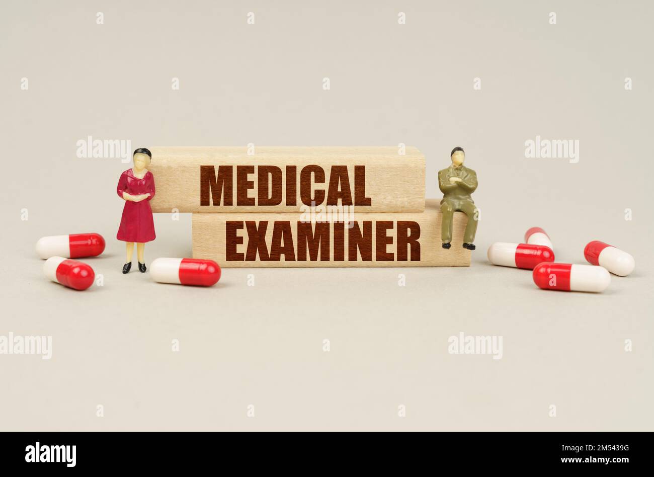 Medical concept. Next to the miniature figurines of people are tablets ...