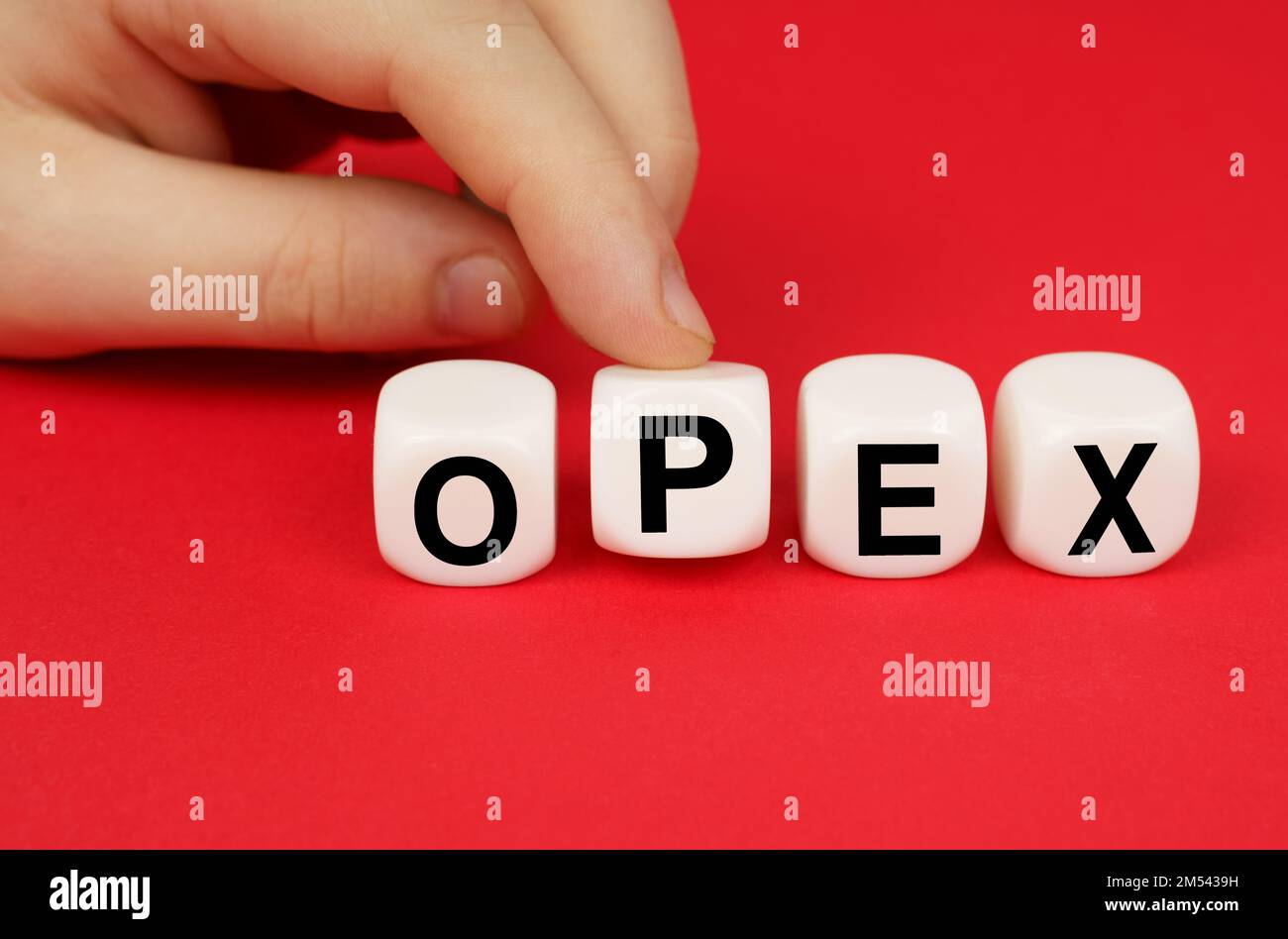 Business concept. On a red background, a person's hand moves the cubes ...