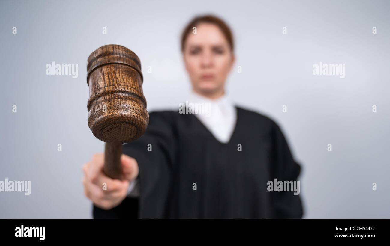 Steadfast female judge in a robe holding a court gavel Stock Photo - Alamy