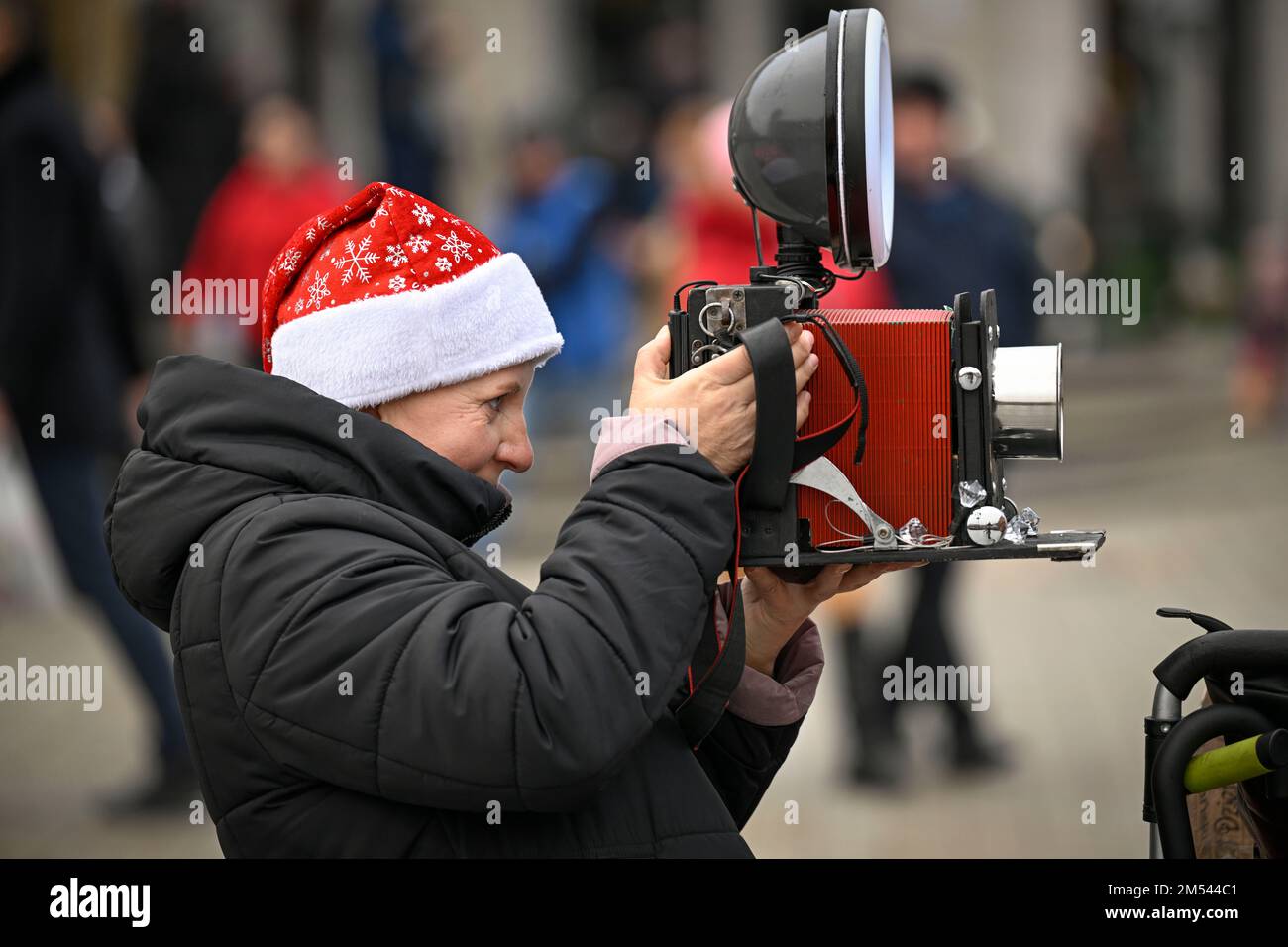 Warsaw, Poland. 25th Dec, 2022. A photographer takes photos of tourists ...