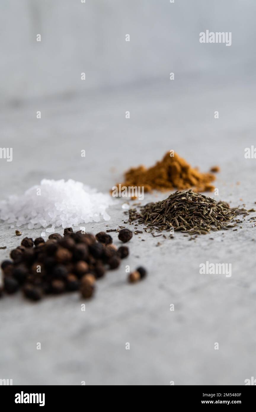 A vertical shot of a pinch of spice, pepper and salt isolated on a ...