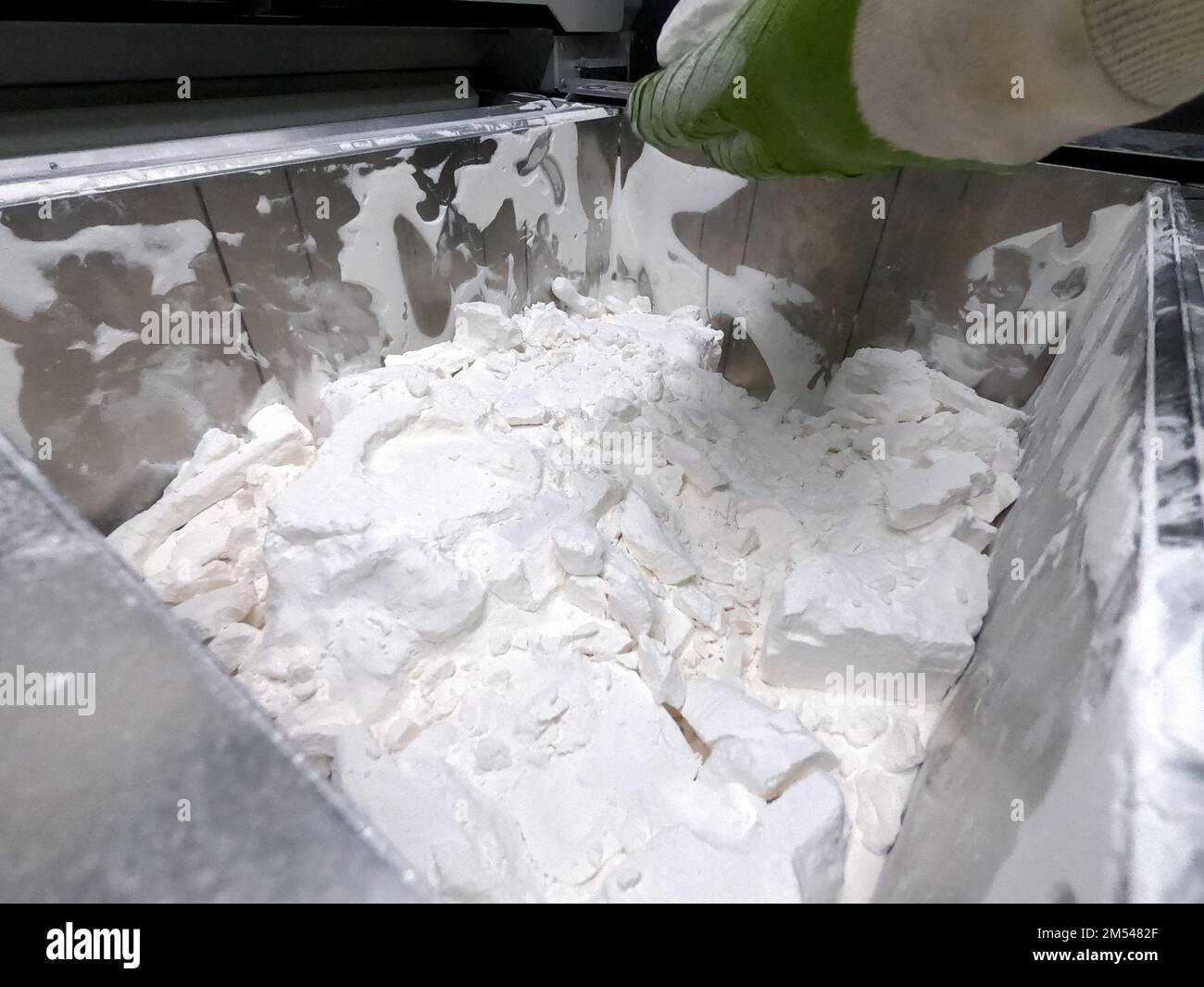 Mane taking out models from white polyamide powder in working chamber ...
