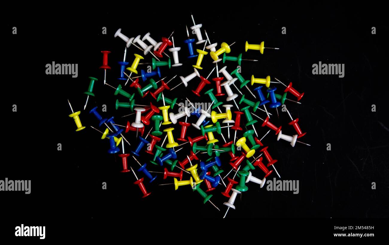 colorful thumbtacks on black background Stock Photo - Alamy