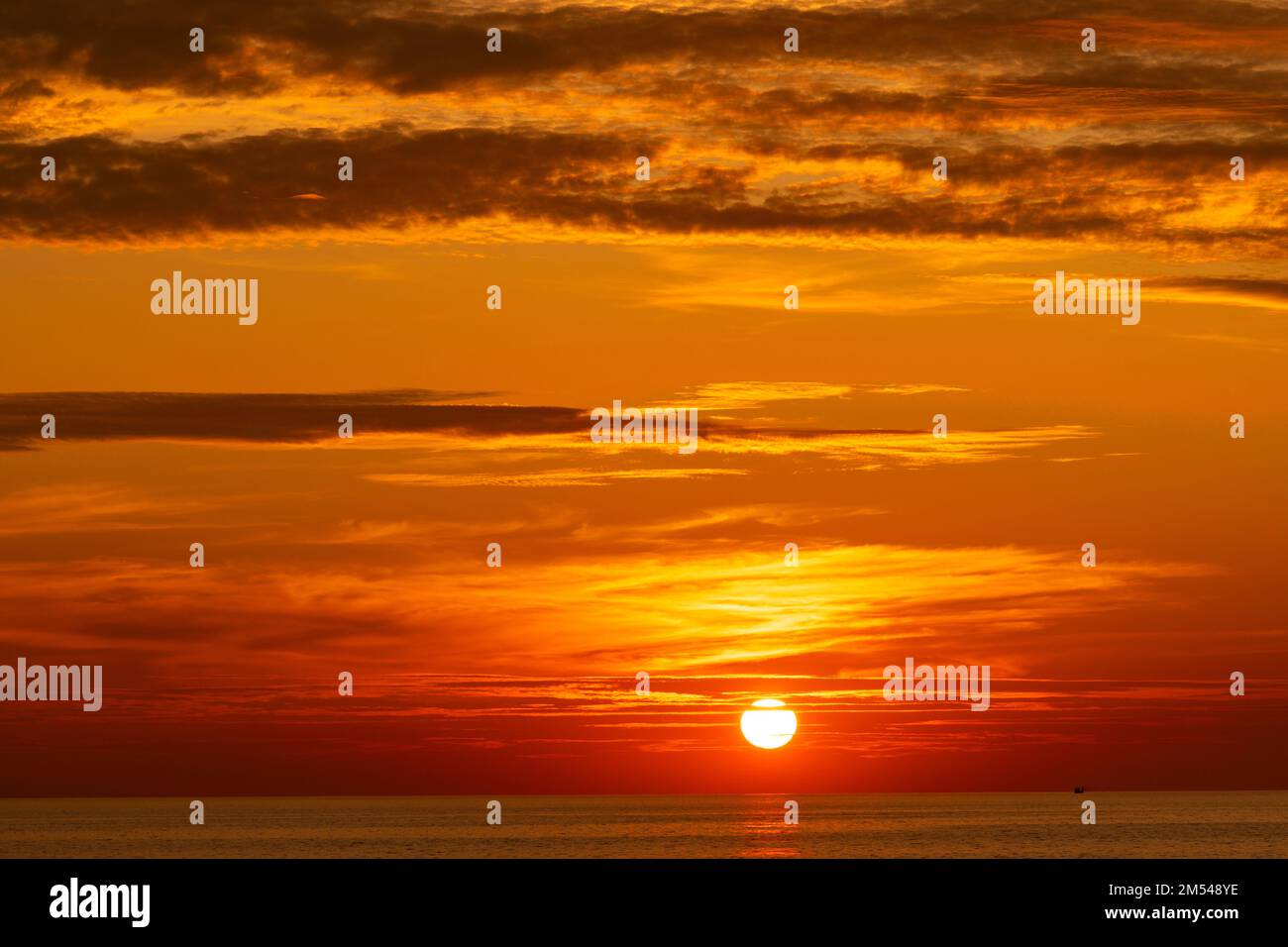 Beautiful light nature red sun in the golden sky and dark clouds ...