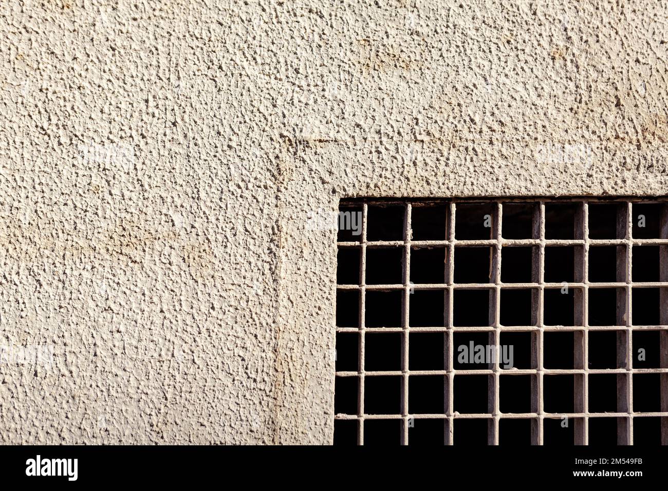 Metal grating in stone wall . Prison window with grates Stock Photo - Alamy