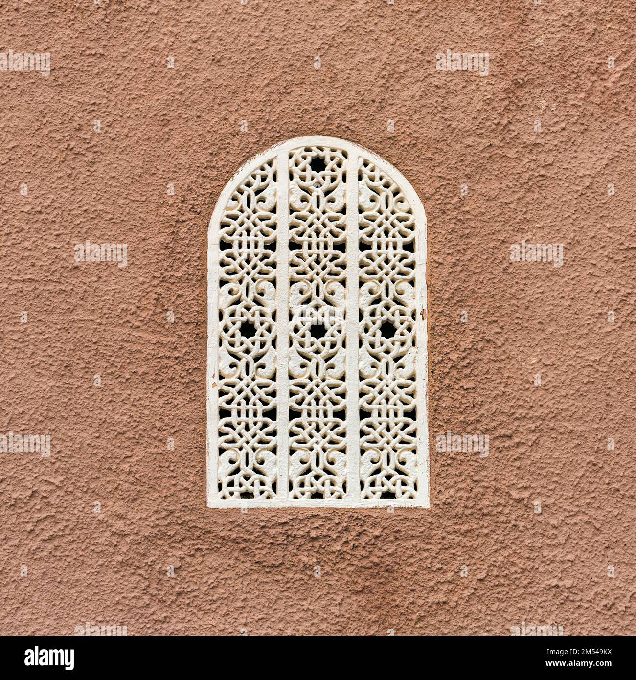 Window with white lattice in terracotta-coloured wall, ornaments ...