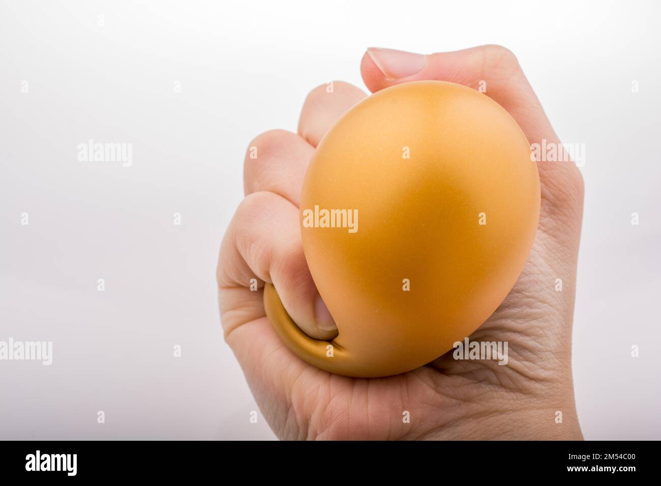 Squeezing yellow balloon with hand on a white background Stock Photo ...