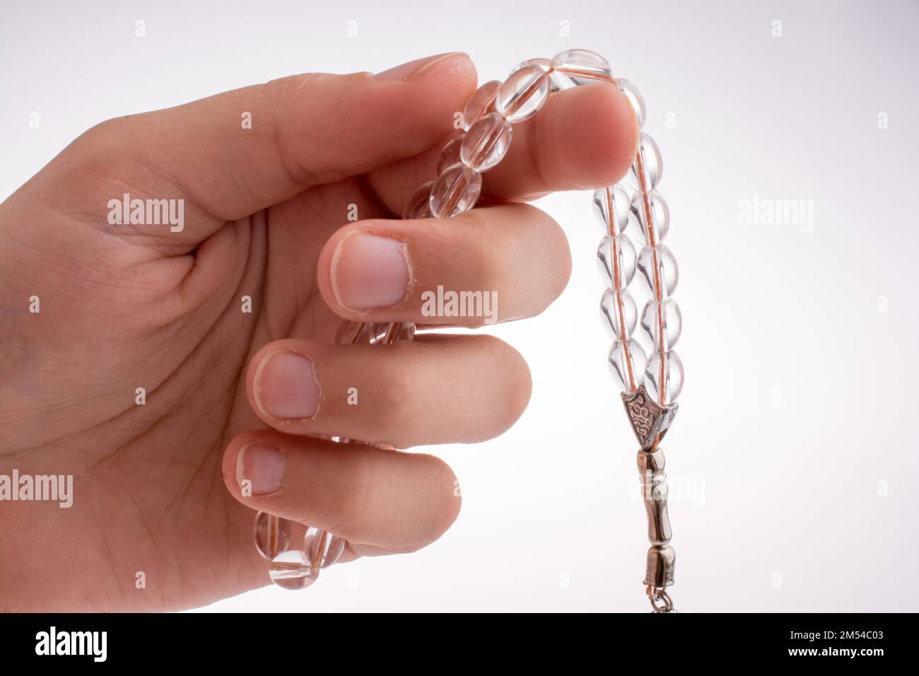 Hand holding a tespih on a white background Stock Photo - Alamy