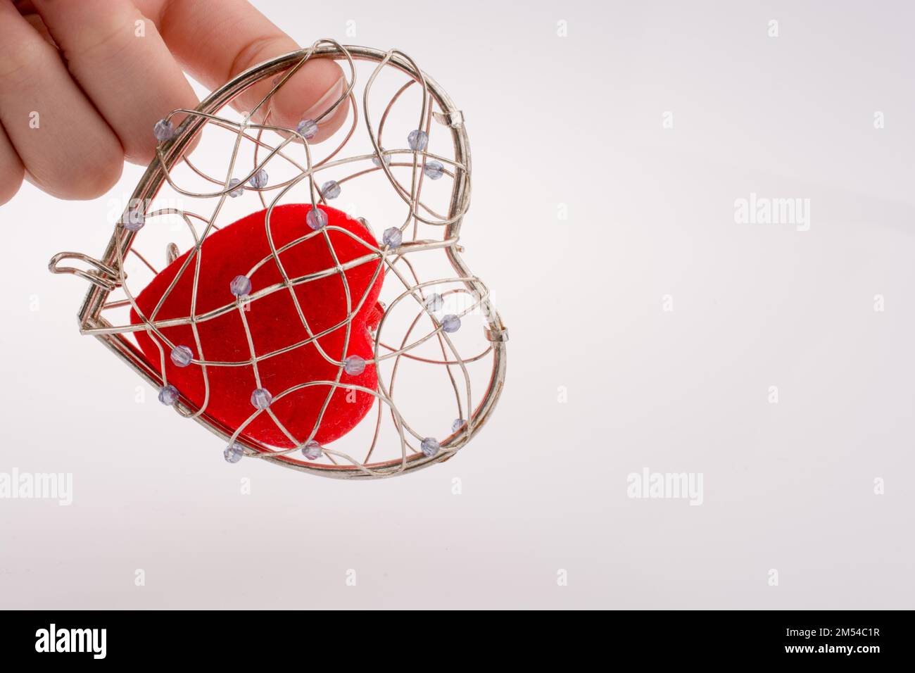 Red heart in a heart shaped cage Stock Photo - Alamy