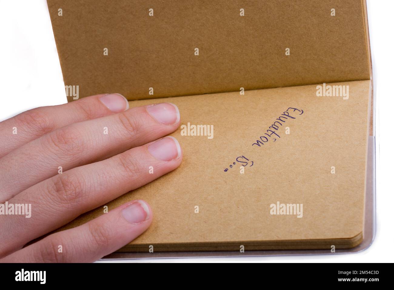 Hand holding a 'Education is. . ' written notebook Stock Photo - Alamy
