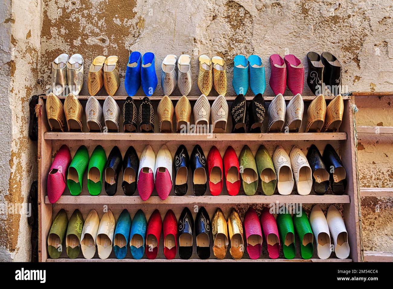 Many colourful Moroccan slippers lined up on a shelf, souvenir shop in ...