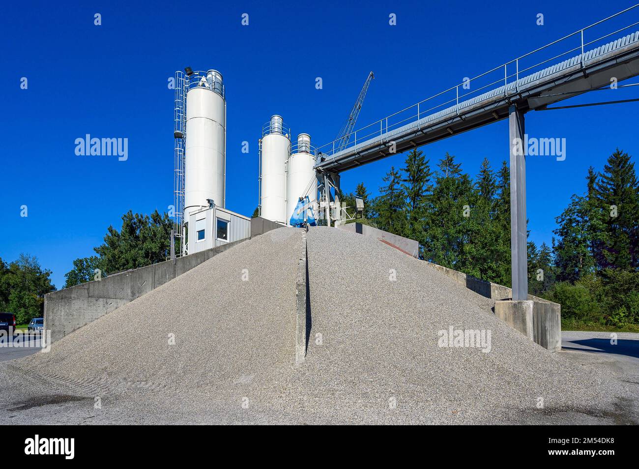 Steel silos and shovel crane with gravel piles and conveyor belt ...