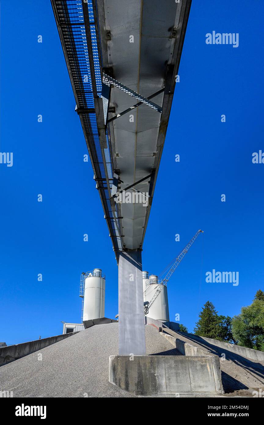 Steel silos and shovel crane with gravel piles and conveyor belt ...