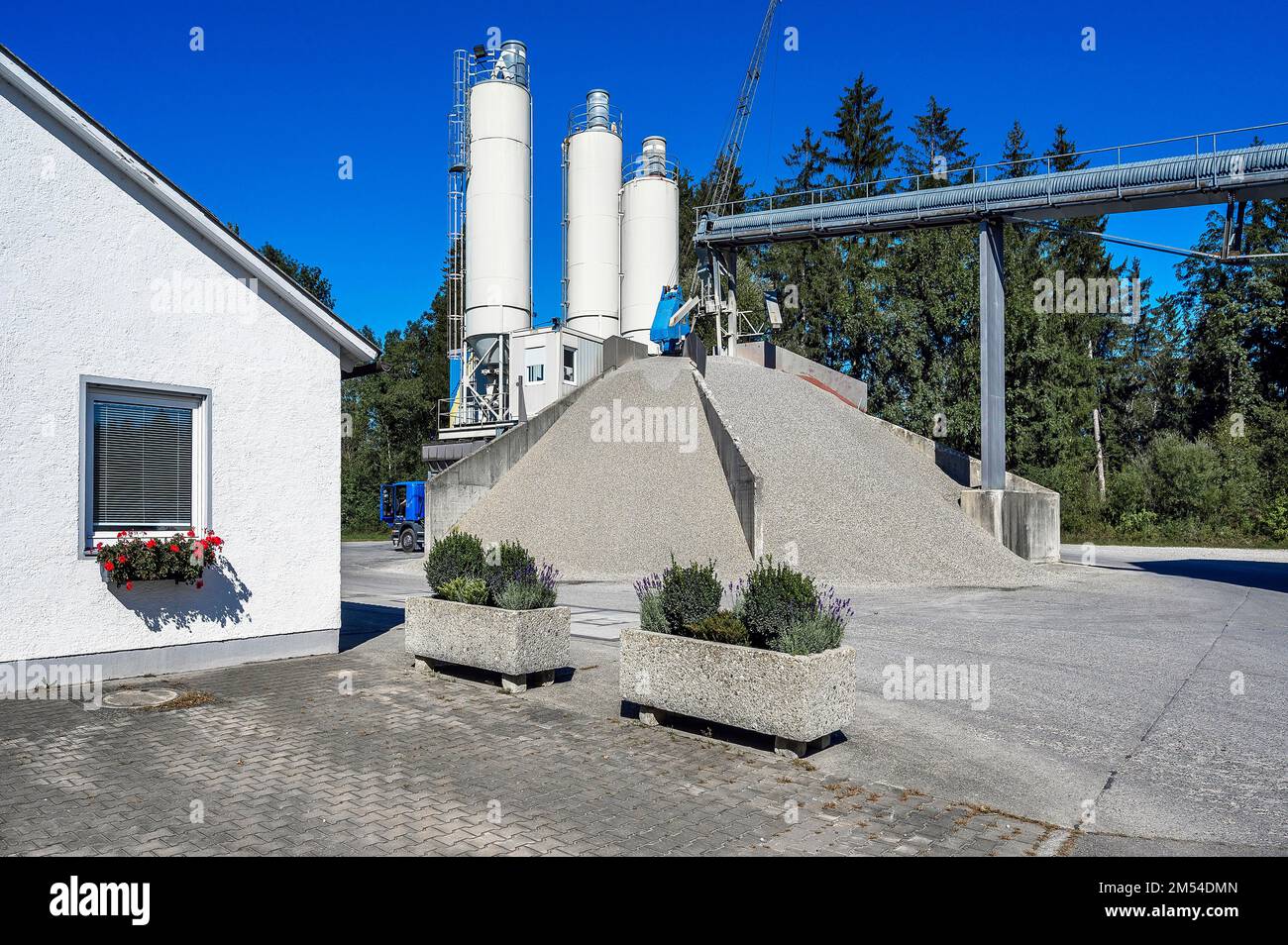 Steel silos and shovel crane with gravel piles and conveyor belt ...