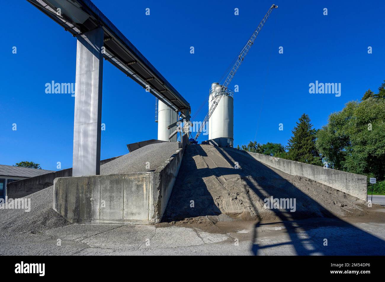 Steel silos and shovel crane with gravel piles and conveyor belt ...