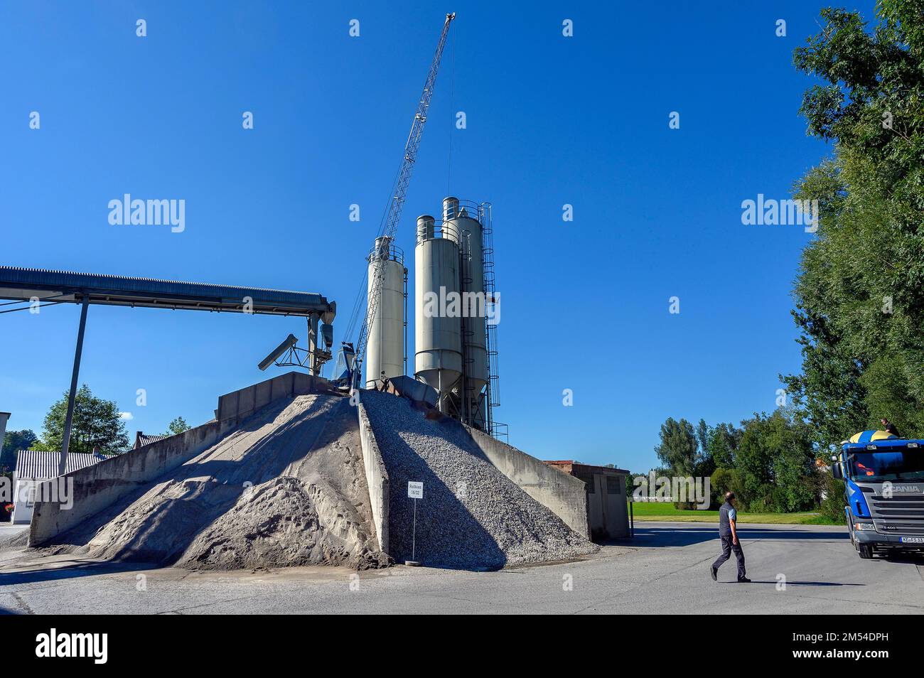 Steel silos and shovel crane with gravel piles and conveyor belt ...