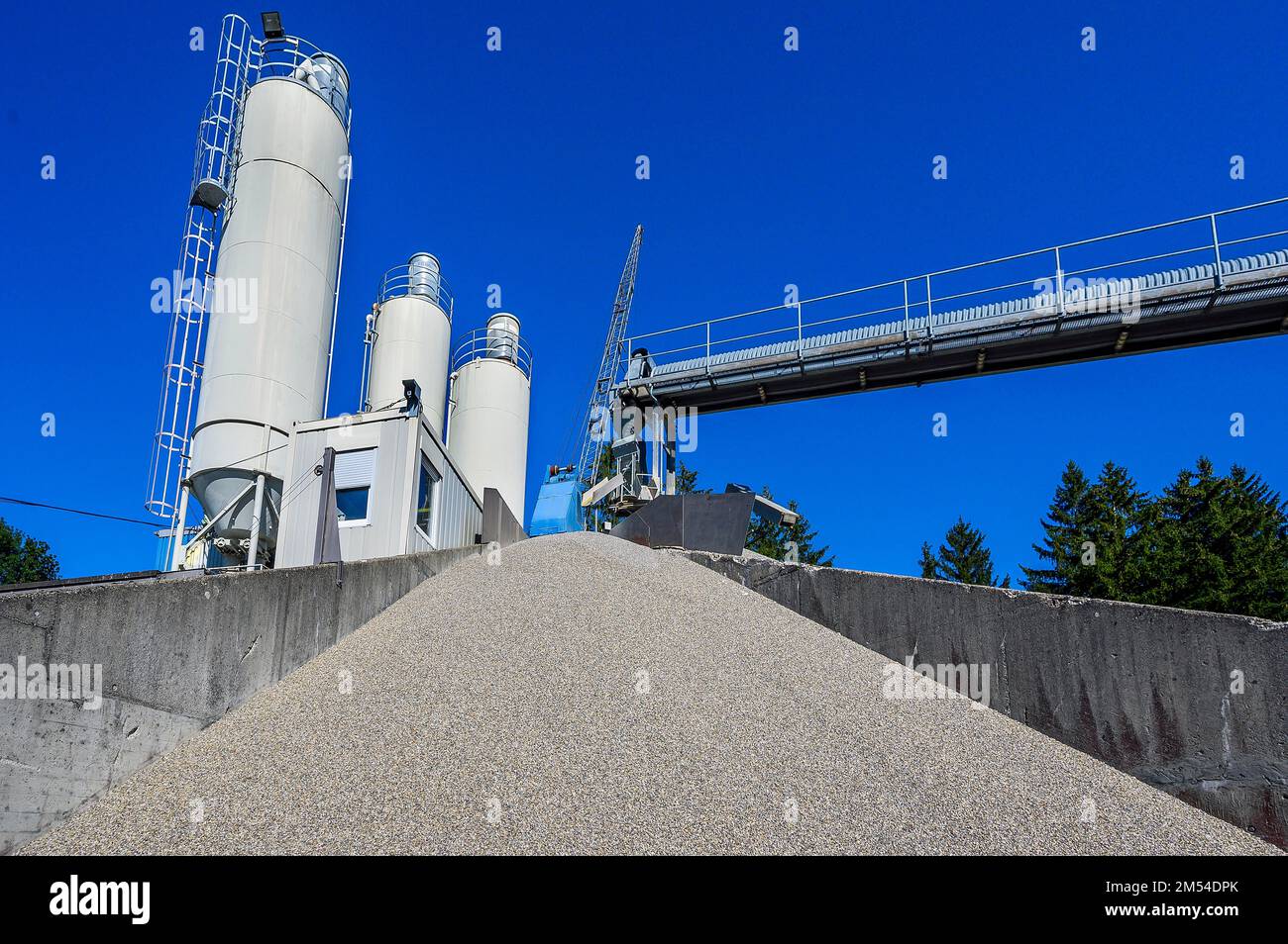 Steel silos and shovel crane with gravel hill and conveyor belt ...