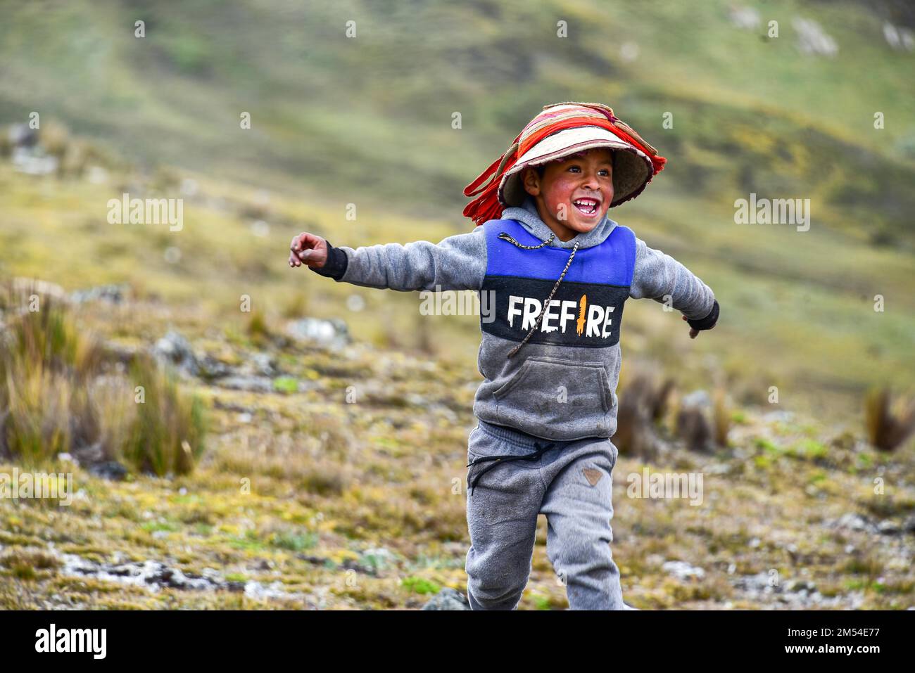 Running boy with traditional hat in the Andes, Ollantaytambo, Urubamba ...