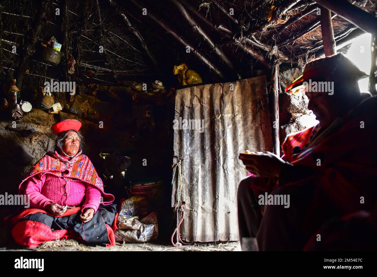 Quechua Indians in traditional dress sitting in their hut, Andes ...