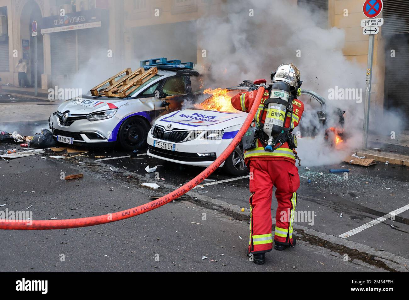 A firefighter intervenes on the two National Police vehicles which were ...