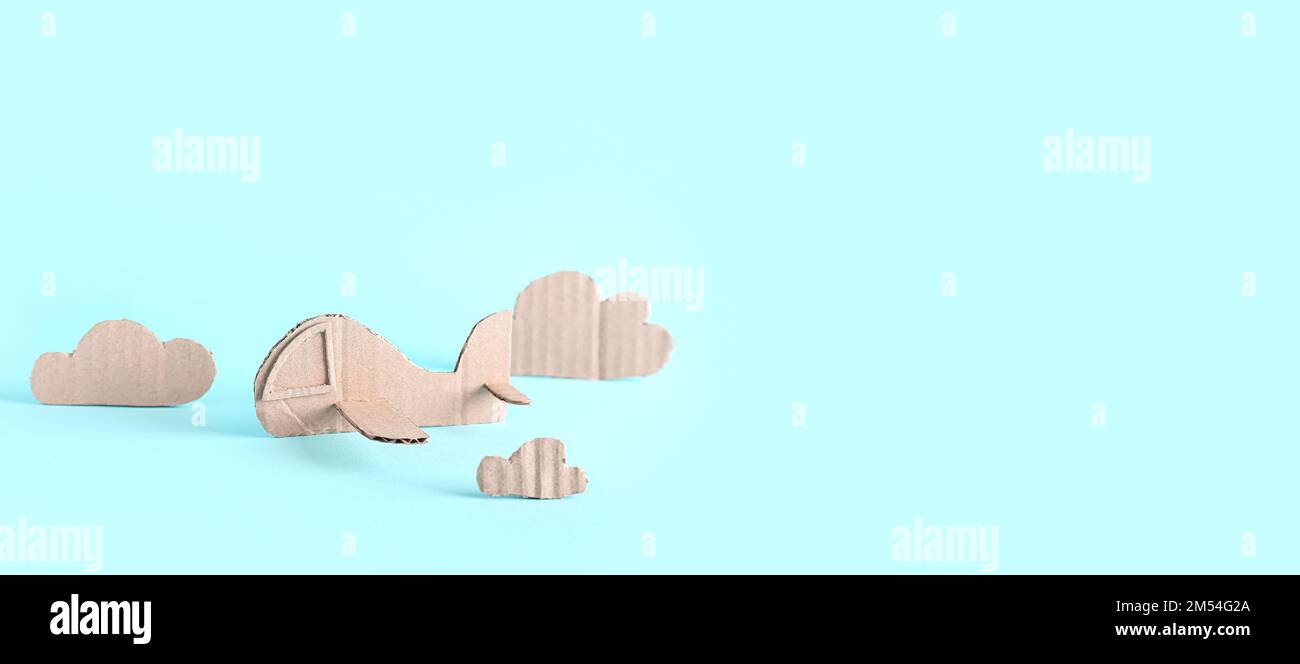 Cardboard airplane with clouds on blue background with space for text ...