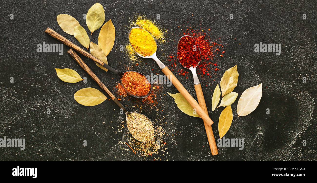Spoons with different spices on dark background Stock Photo - Alamy