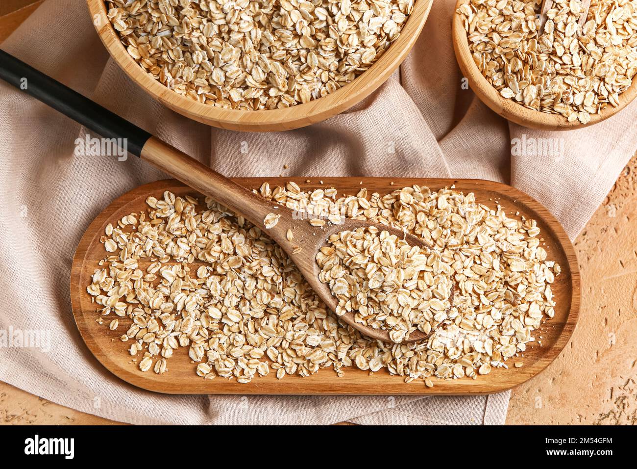 Plate and bowls with raw oatmeal on color table, closeup Stock Photo ...