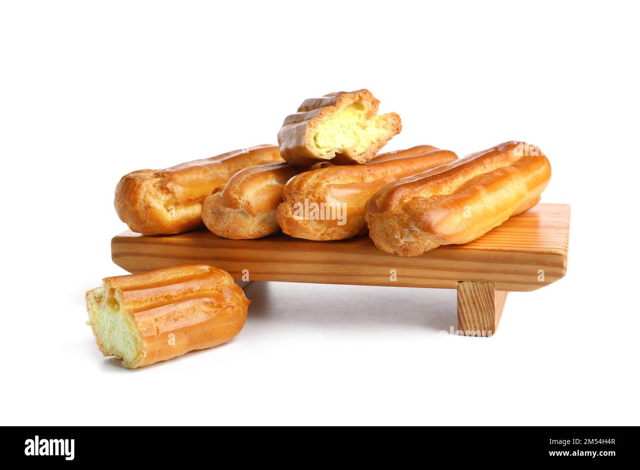 Wooden board with delicious eclairs isolated on white background Stock ...