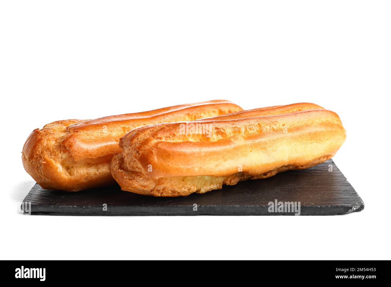Slate board with tasty eclairs on white background Stock Photo - Alamy
