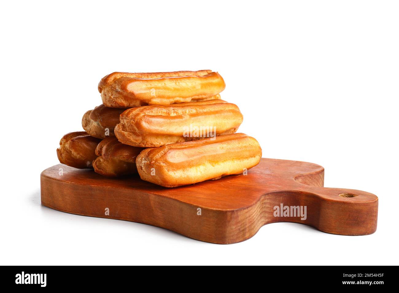 Wooden board with tasty eclairs isolated on white background Stock ...