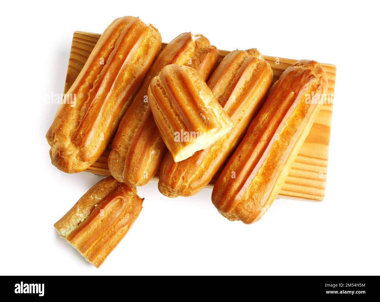 Wooden board with delicious eclairs isolated on white background Stock ...