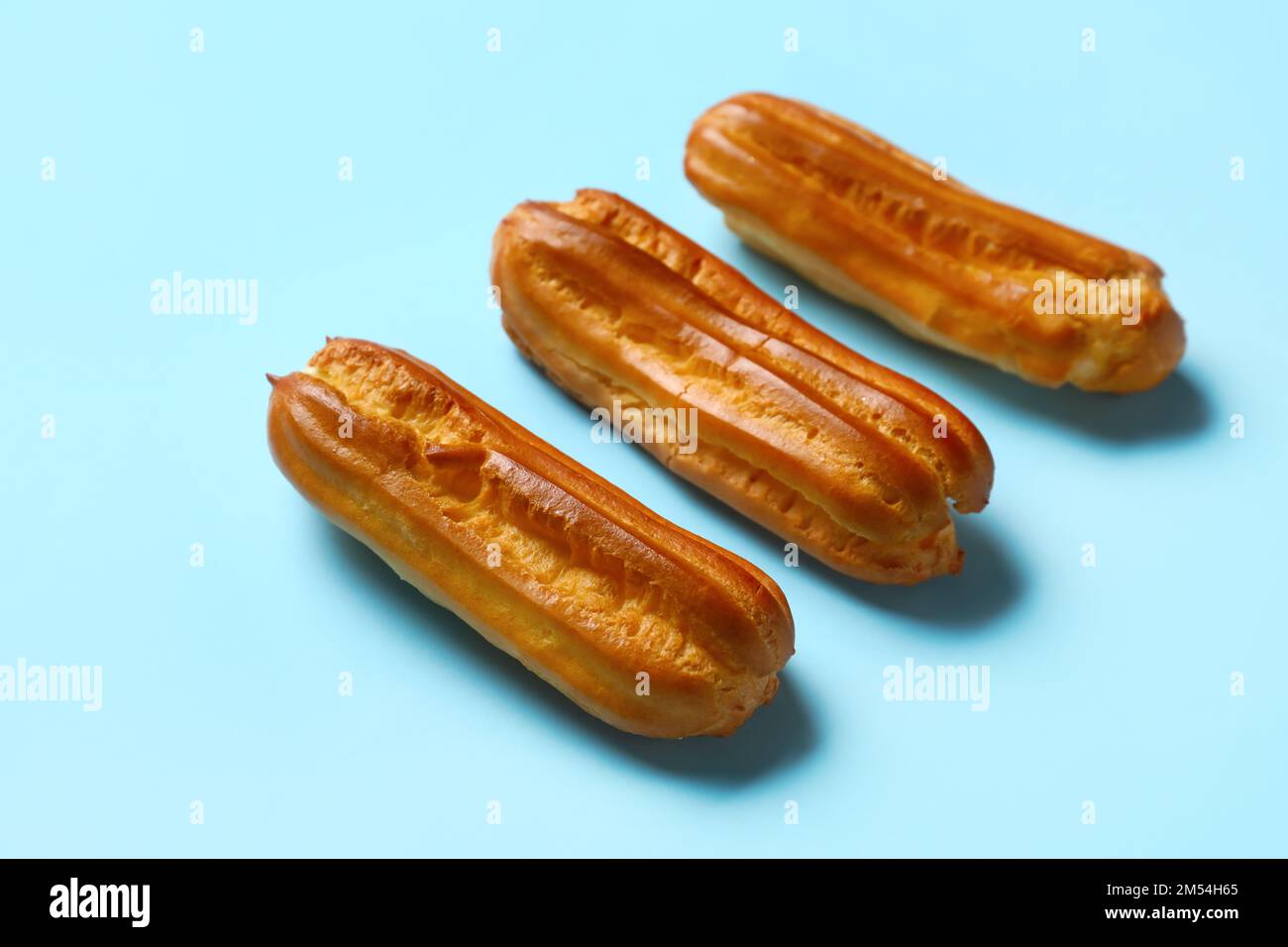 Sweet eclairs on blue background Stock Photo - Alamy