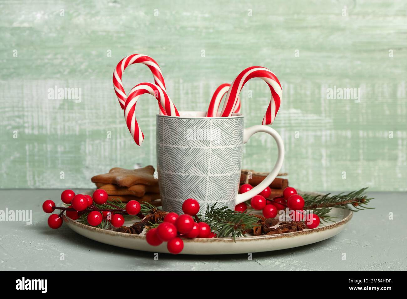 Cup of tasty candy canes, Christmas decor, cookies and spices on table ...